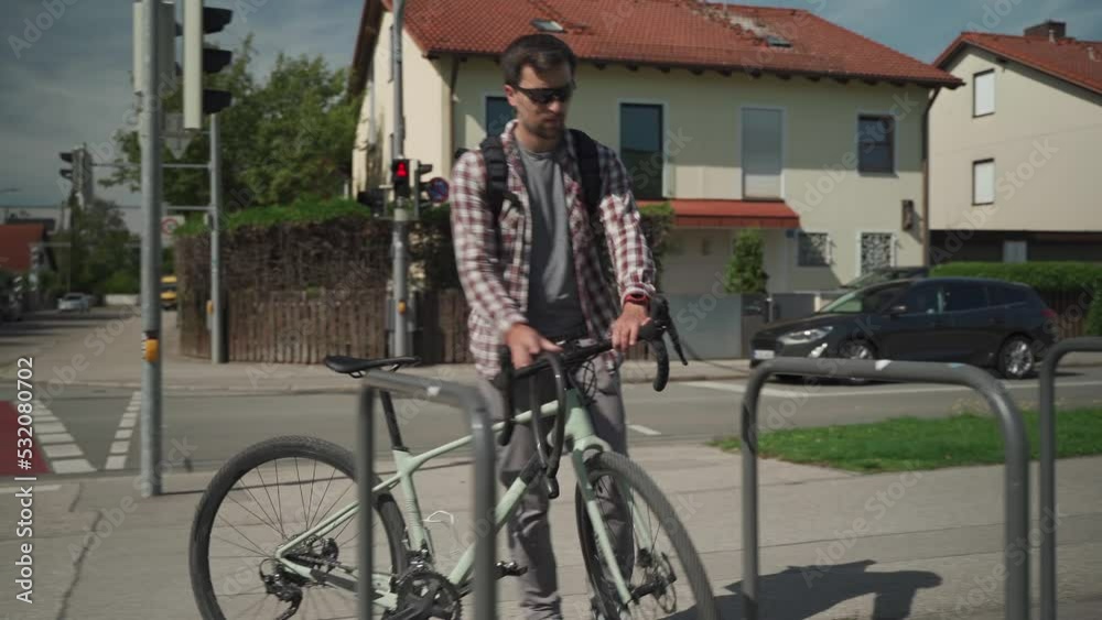Cyclist parks and locks bicycle in public bike parking lot in Germany ...