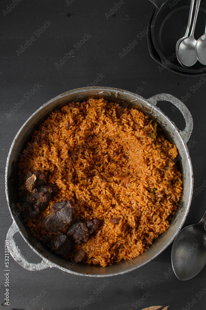 Jollof rice and fried beef in a cast iron pot, Nigerian party jollof ...