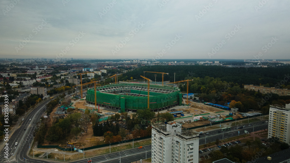 Foto de Building a stadium in a big city. Construction site among urban ...