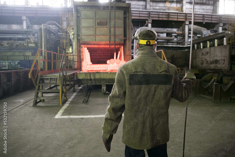 Steelworker at work. Metallurgist working at the hot furnace of a steel ...