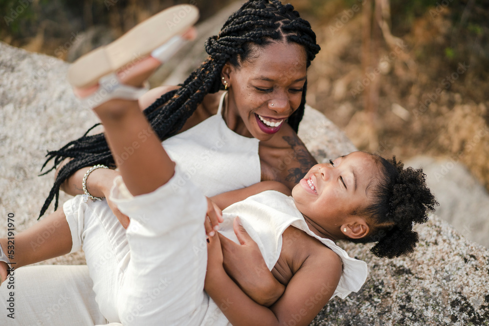 Black mom tickling cheerful daughter Stock Photo | Adobe Stock