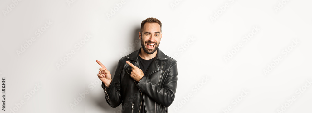 Cheeky guy in leather biker jacket, winking flirty and pointing at ...