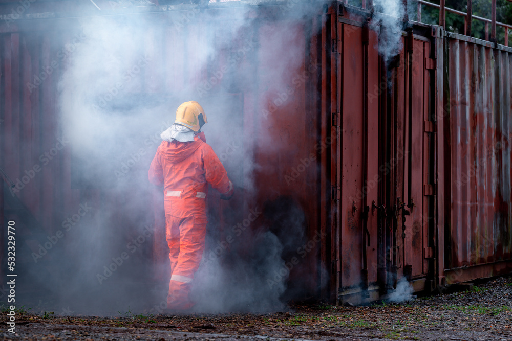 Firefighter with fire suite standing in front of frightening explosion ...