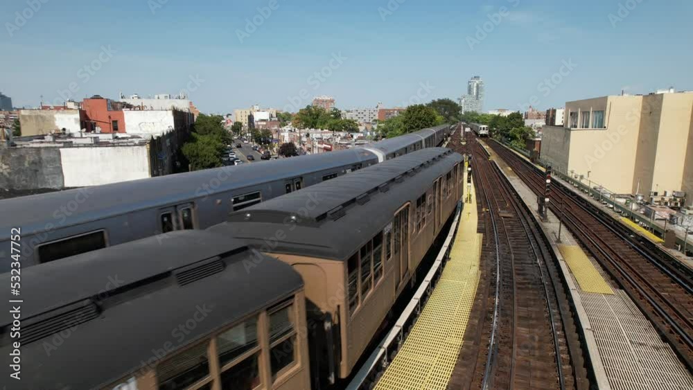 An aerial view of elevated tracks with a historic train travelling away ...