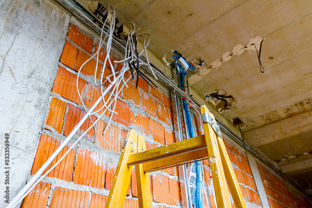 View on ladder and cable tray with bundle of cables between floors in ...
