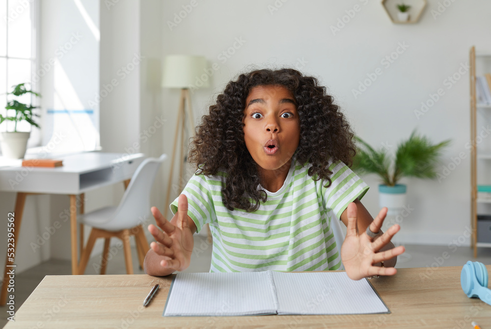 Portrait of surprised school child. Little African American student ...