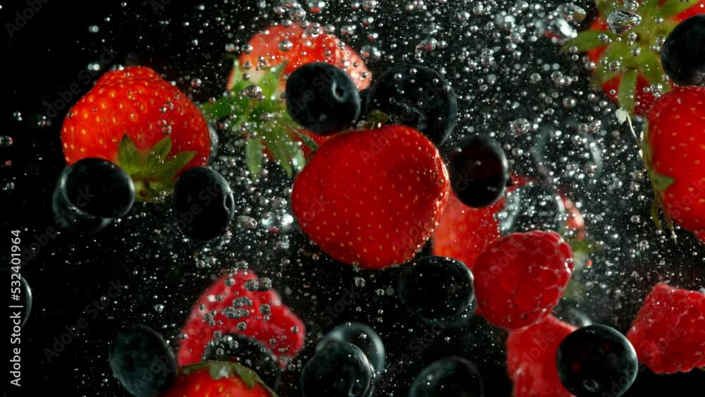 Vidéo Stock Super slow motion of falling berries mix into water on ...