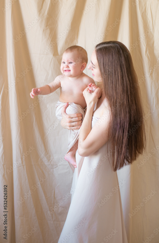 Young Mother With Long Dark Hair Holding A Cute Little Daughter In Her