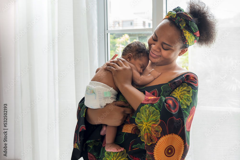 African mother smile and holding a 2-month-old baby newborn son who is ...