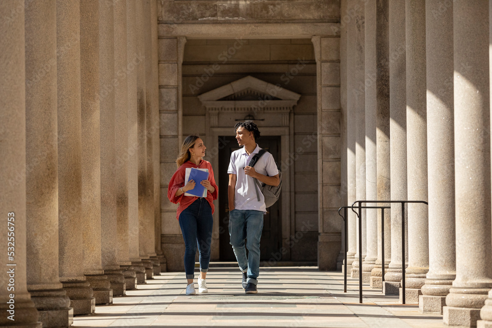 Two Friends University Students walk in campus hallway outdoors Stock ...