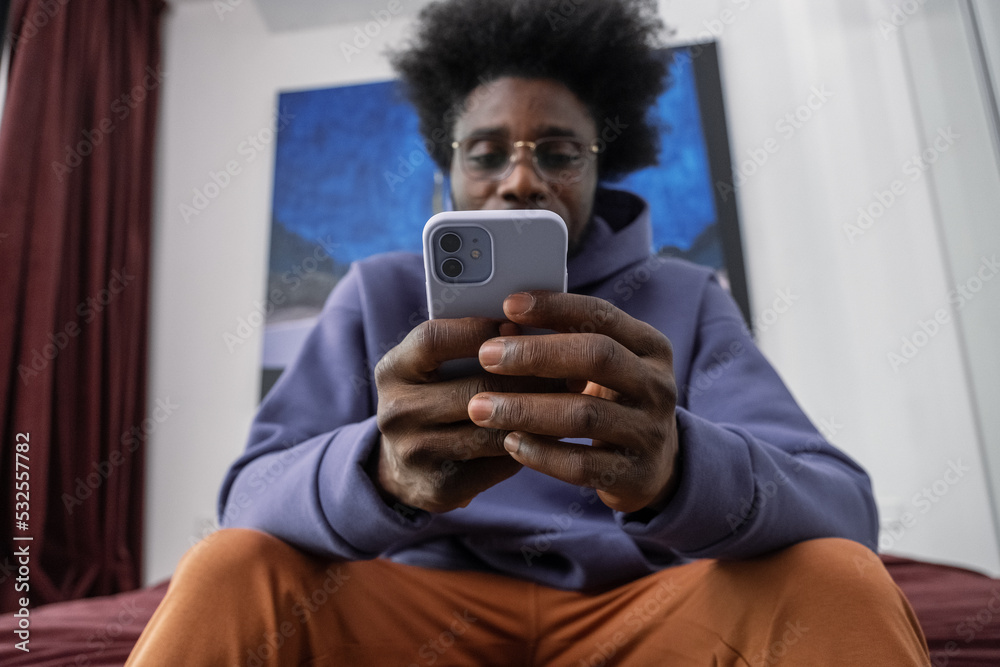 Black male scrolling social media on smartphone Stock Photo | Adobe Stock