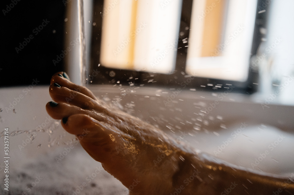 Crop woman splashing water in bathtub Stock Photo | Adobe Stock