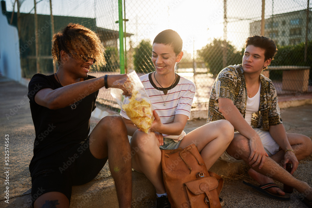 Merry friends eating chips on street Stock Photo | Adobe Stock