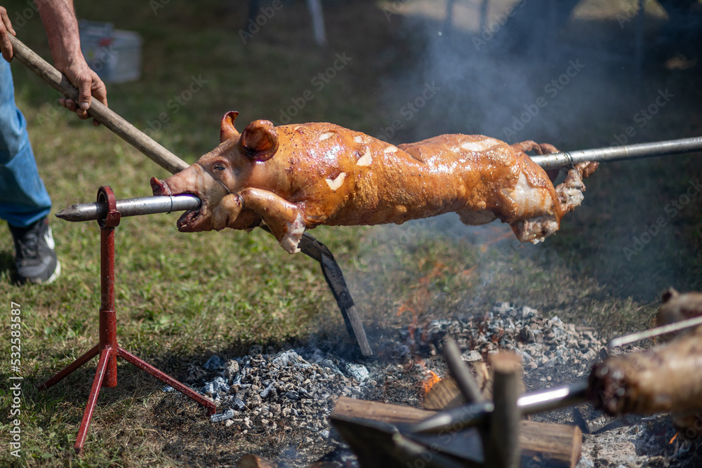 Whole pig roasted on a barbecue spit. Outdoor Barbecue grill a classic ...