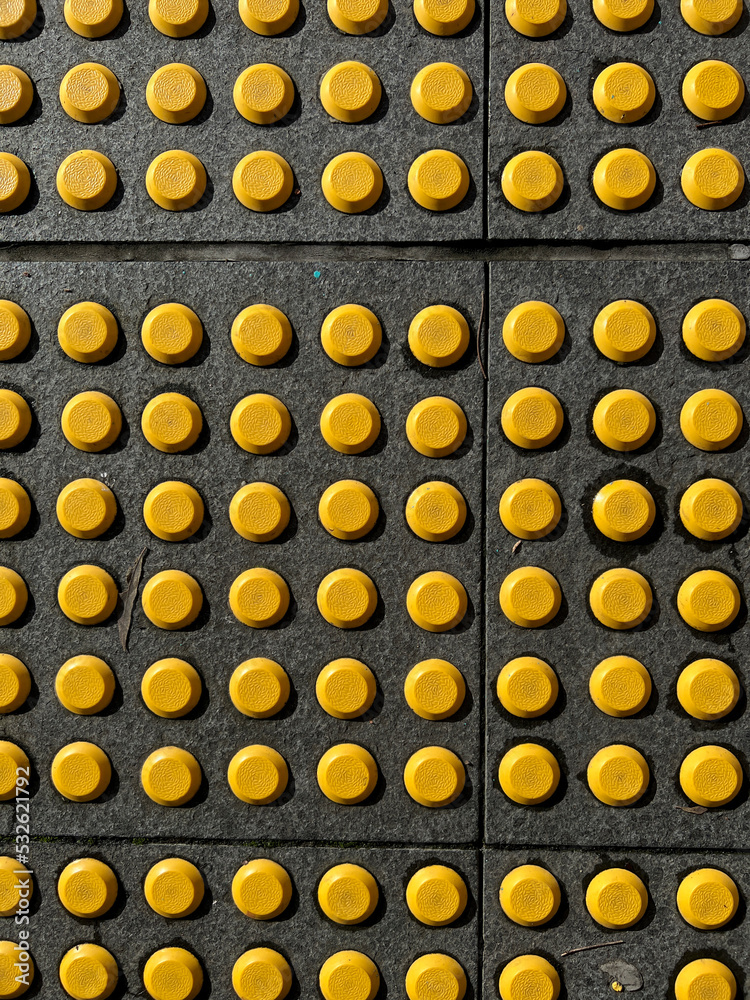 Yellow plastic dots on sidewalk Stock Photo | Adobe Stock