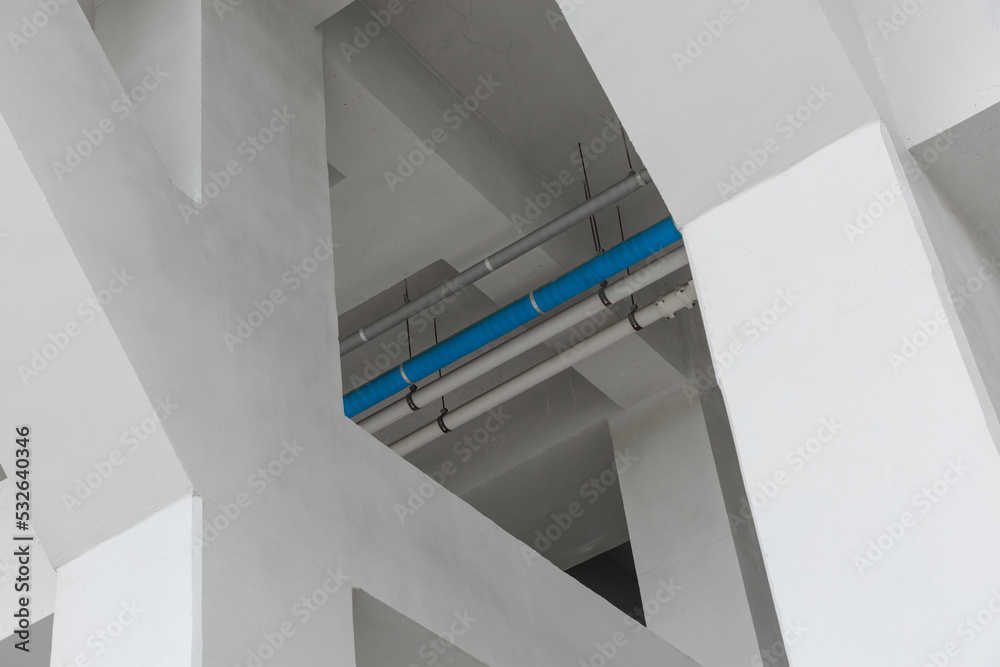 Blue pipe between columns of concrete building. Stock Photo | Adobe Stock