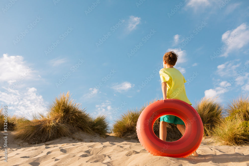 Back view tween boy holding float a float tube by blue sky Stock Photo ...