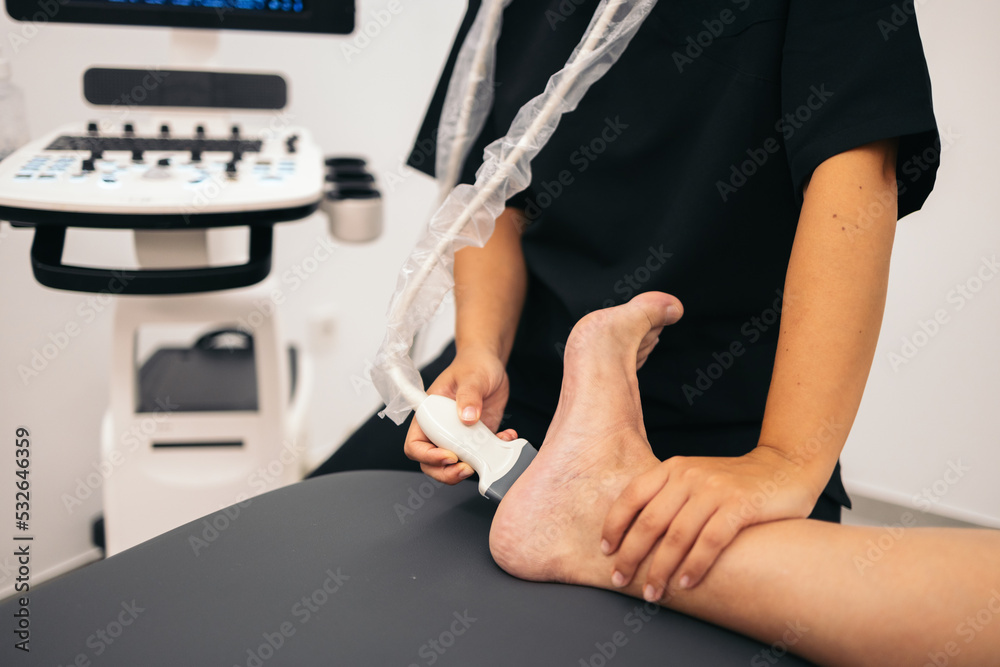 Professional physiotherapist doing an ultrasound scan to a patient ...
