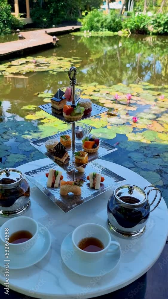 Stockvideo Afternoon tea at a water pond, high tea in a tropical garden ...