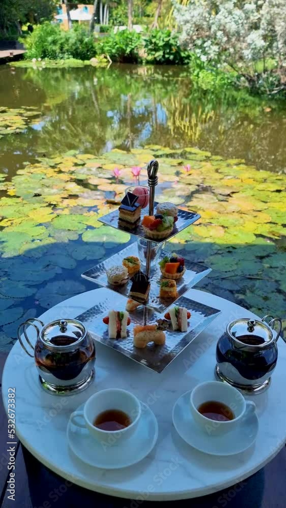 Stockvideo Afternoon tea at a water pond, high tea in a tropical garden ...