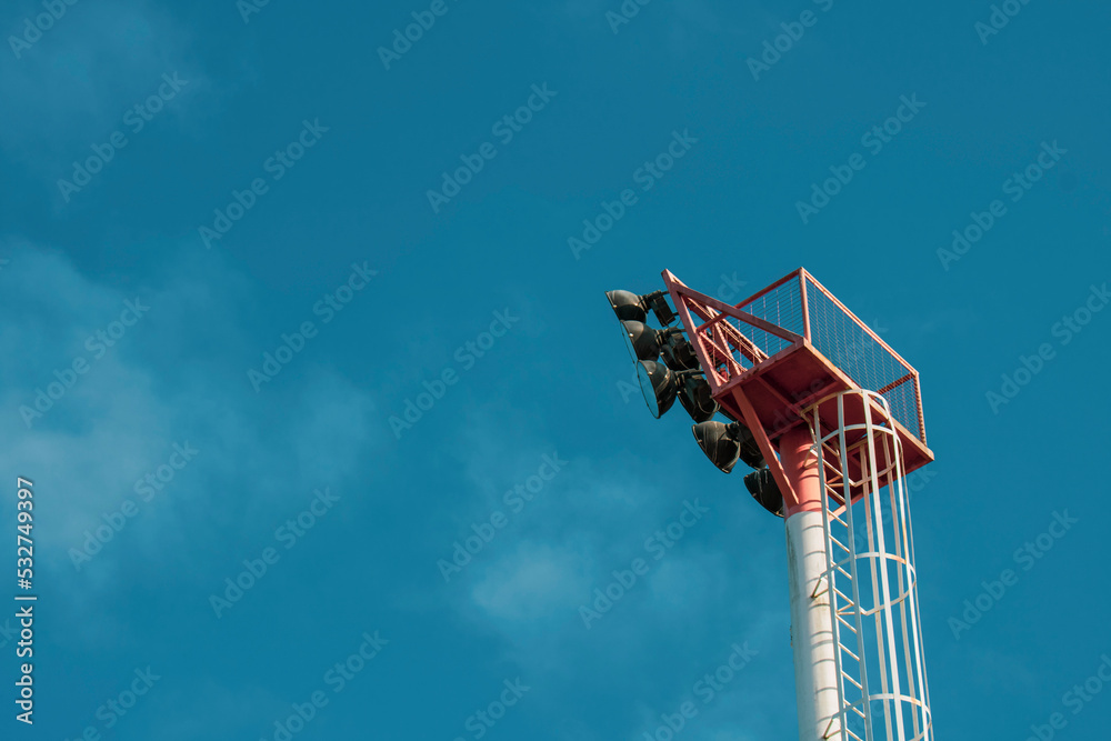 light tower with red and white colors of a football soccer stadium with ...