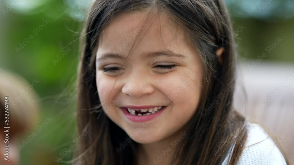 Portrait of a happy little girl closeup face with missing teeths ...