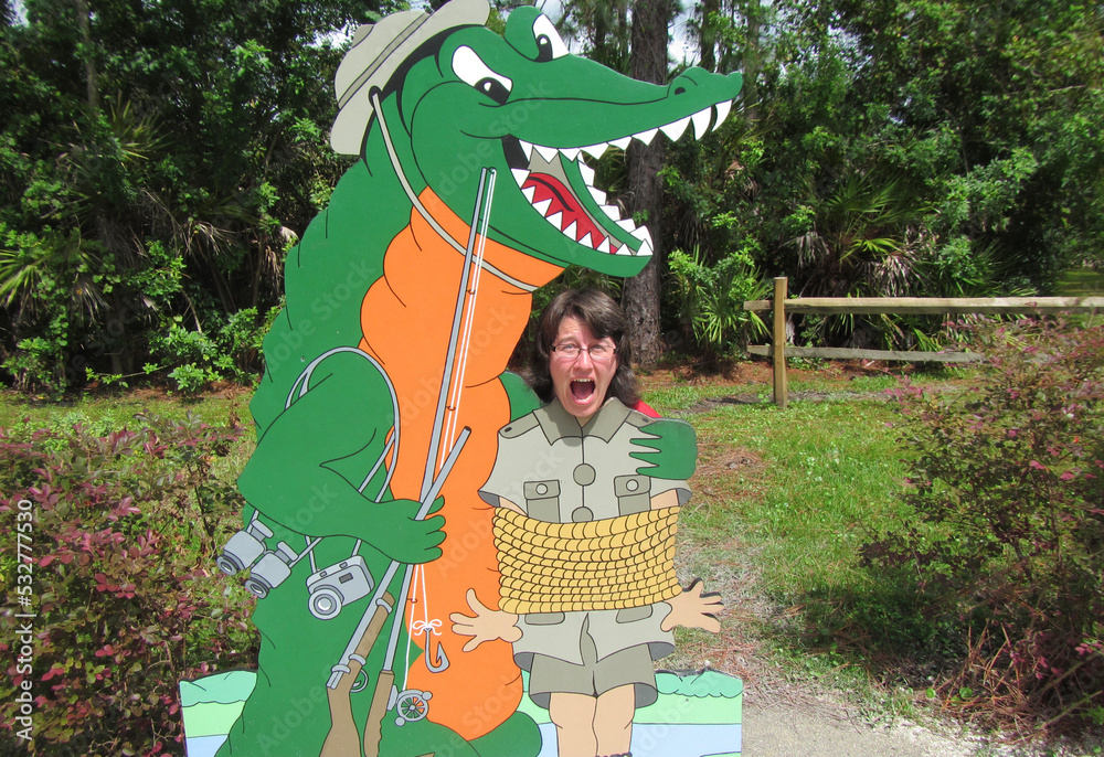 Poster A female being captured by an cardboard cutout of an alligator ...