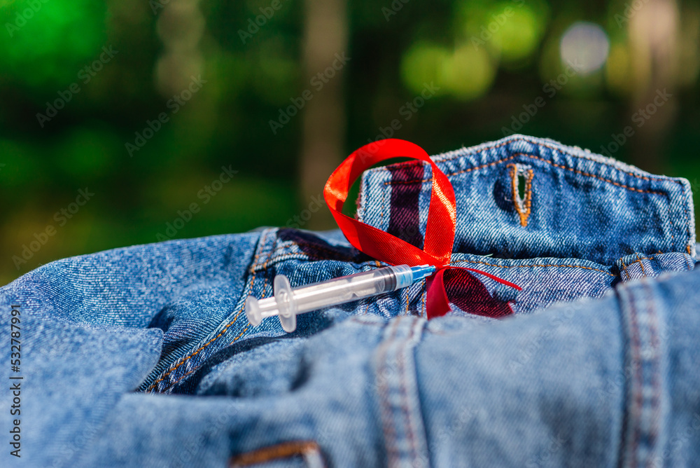 Red ribbon,syringe,needle,denim jacket. symbol HIV,AIDS cancer ...