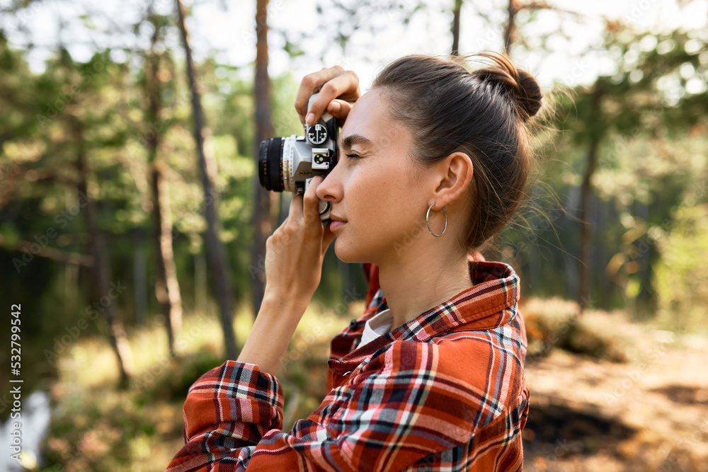 Profile view of pretty woman photographer taking picture of picturesque ...
