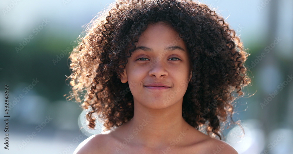 African preteen girl smiling at camera. Black child standing outside ...