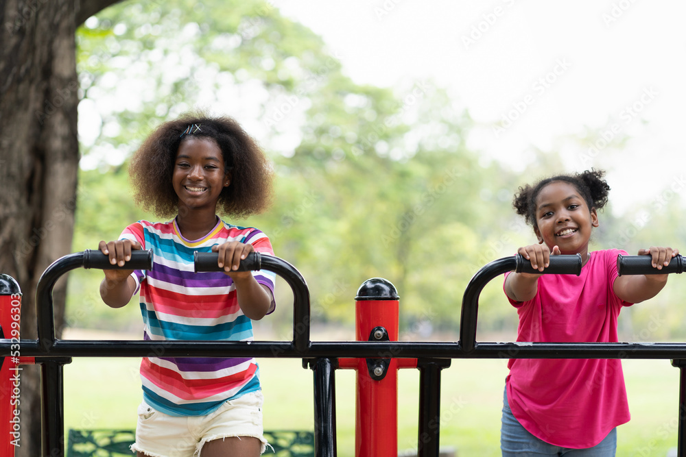 Smiling two African American child girl playing together at the ...