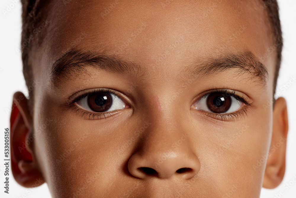 Close-up of little boy face with dark brown eyes expressing emotions ...