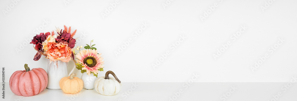 Autumn decor on a white shelf against a white wall banner background ...