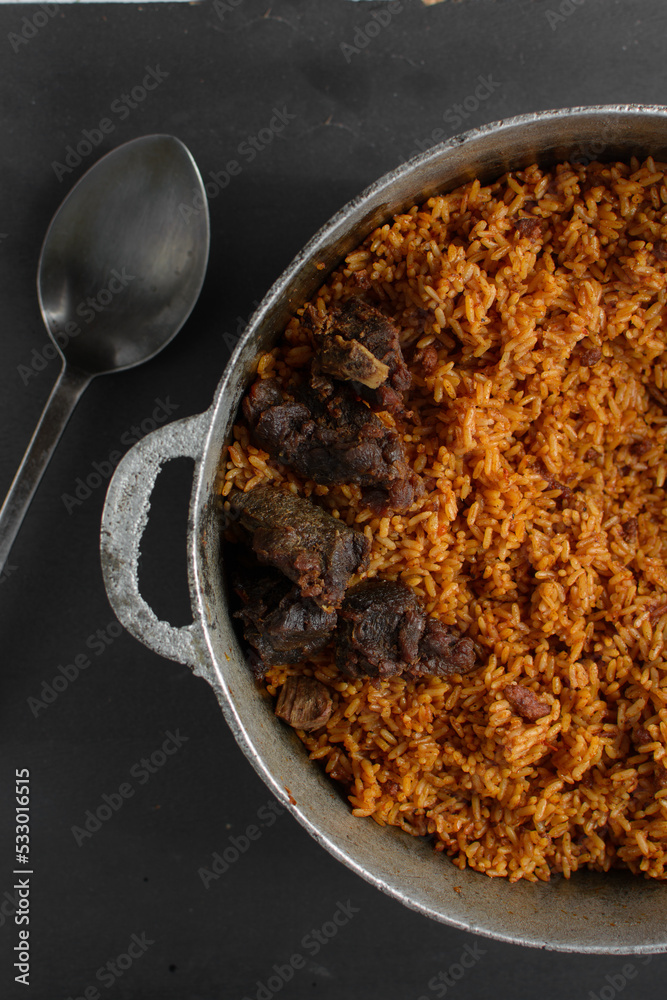 Jollof rice and fried beef in a cast iron pot, Nigerian party jollof ...
