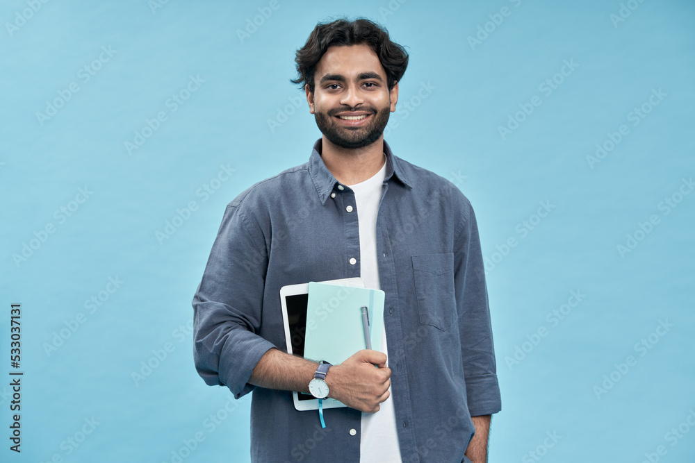 Smiling happy arab young man student standing isolated on blue ...