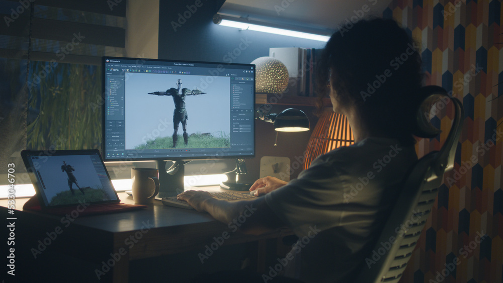 Fotka „Male 3D designer sitting at the table at home and making ...