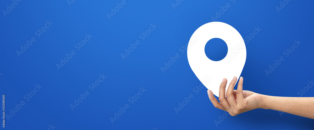 Hand holding shape of white location icon on blue background. Stock ...
