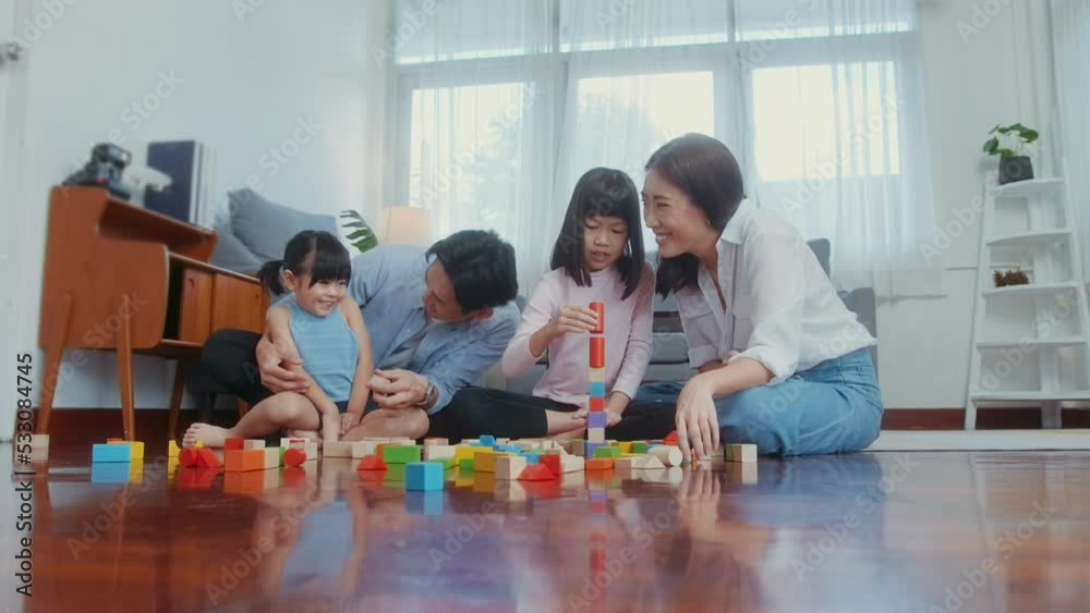 Asian family with children playing and building tower of colorful ...