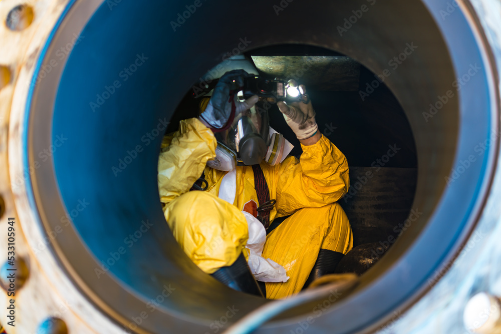 Employees inspect by taking photographs of internal pressure tanks in ...