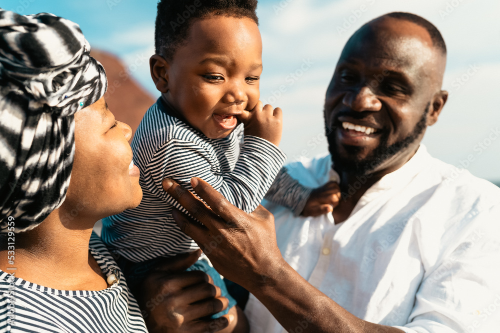 Happy African family having fun on the beach during summer vacation ...