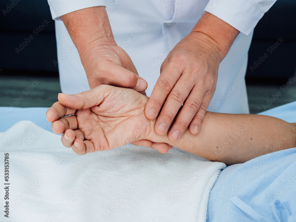 Close up doctor's hand in white lab coat holding elderly patient's hand ...