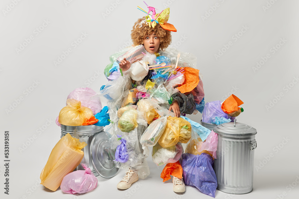 Plastic pollution concept. Scared emotional curly woman overloaded with ...