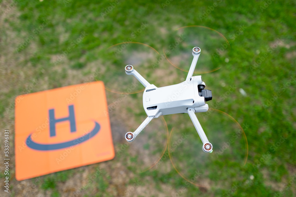 Intelligent droneUAV seen taking off from a launch mat located on grass ...