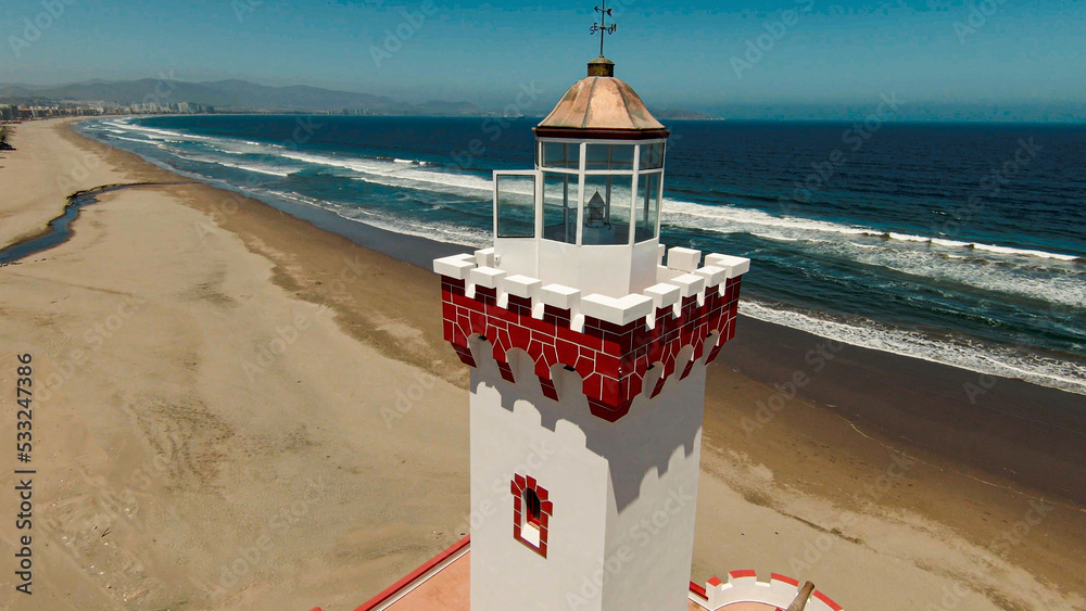 Foto de Torre de un faro de color blanco y rojo a orillas de una playa ...