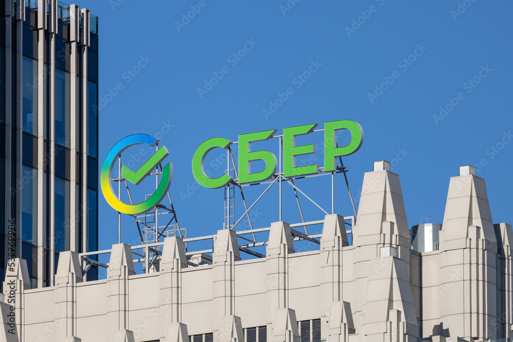 Green SBER signboard on the roof of a high-rise building, close-up. The ...