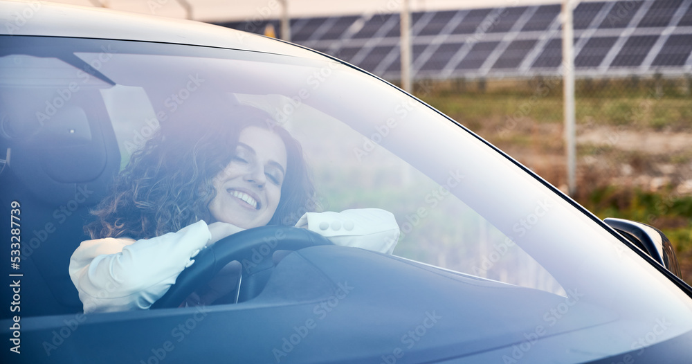 Close-up view of happy woman placing chin on folded arms at wheel of ...