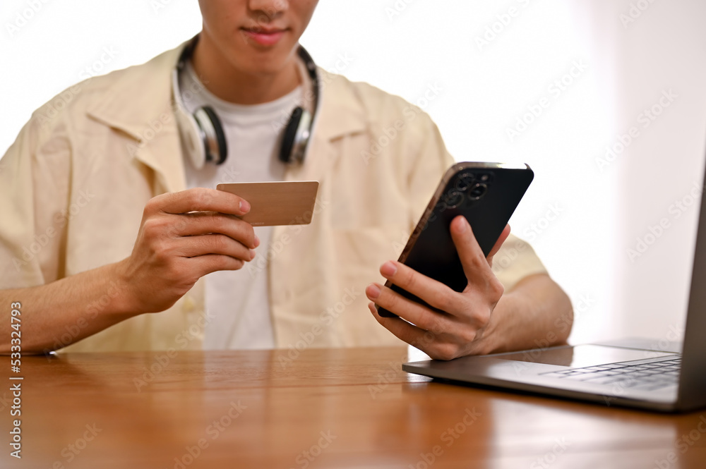 Handsome Asian man using a smartphone to pay his shopping bills, using ...
