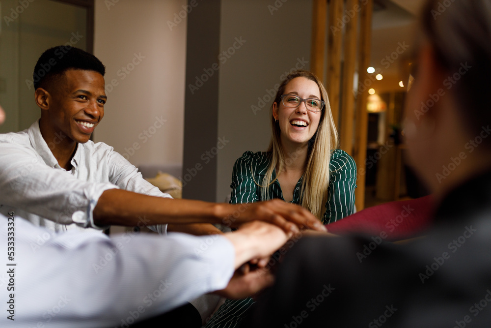 Positive diverse business team putting their hands on top of each other ... Positive diverse business team putting their hands on top of each other ...