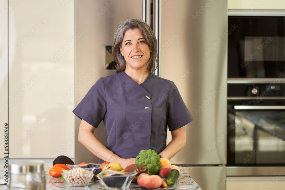 portrait of woman nutritionist in the kitchen with vegetables on the ...