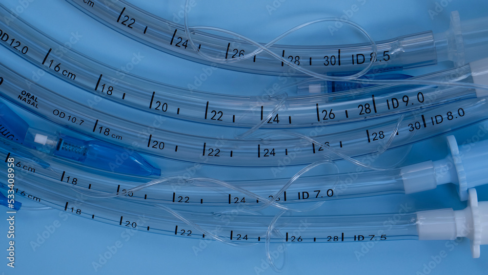 endotracheal tubes of different sizes and diameters lie on a light blue ...